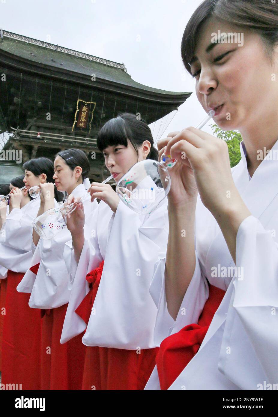 Miko, Japanese Shinto female attendants play the lucky charm glasswork ...