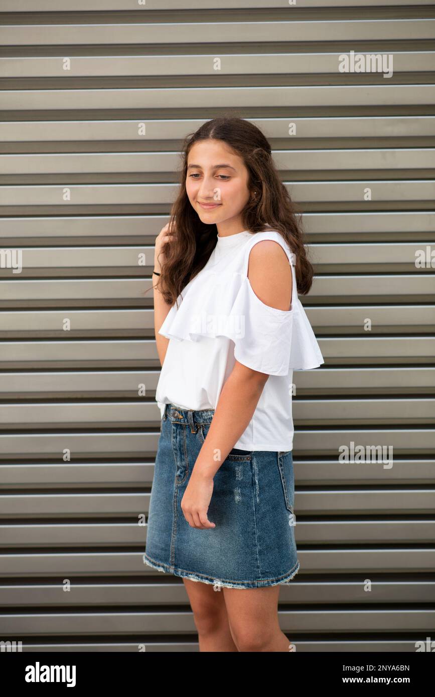 Beautiful teenage girl standing outdoors looking down Stock Photo - Alamy