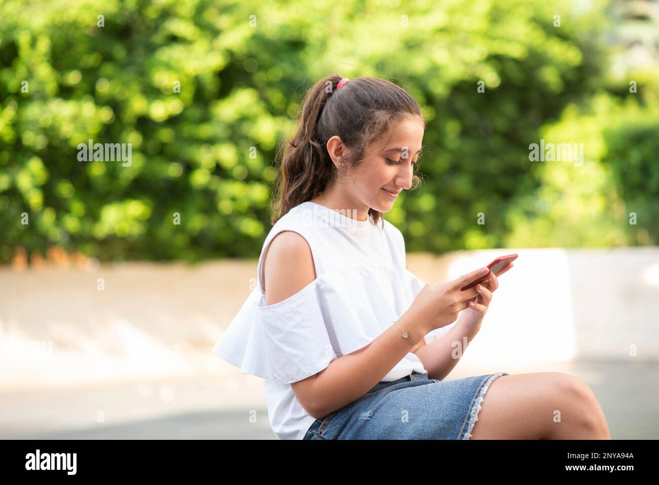 Teenage girl using smart phone outdoors Stock Photo - Alamy