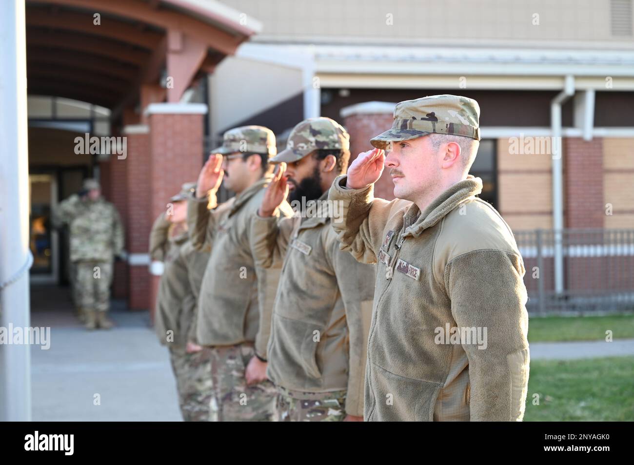 Members of the 174th Attack Wing lower and fold the flag during a ...