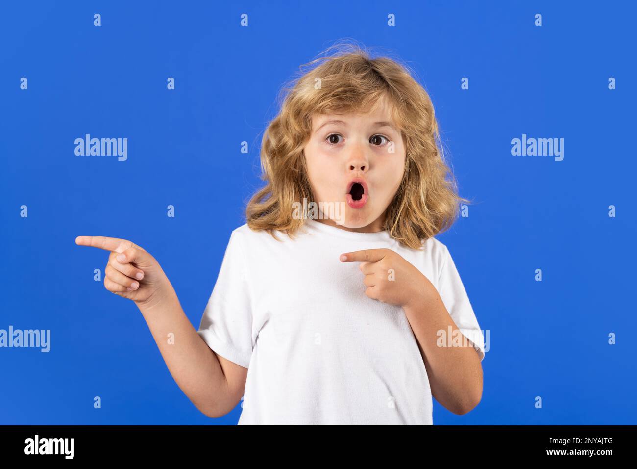 Excited kid boy on studio isolated background. Kid boy pointing away on ...