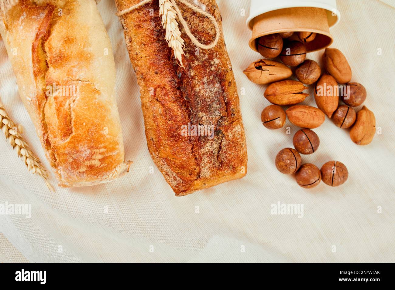 Top view of two baguettebread and nuts on a textile surface. Concept of ...