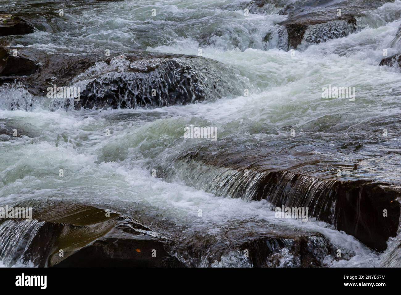 The stream of water flowing over rocks.Image close-up Stock Photo - Alamy