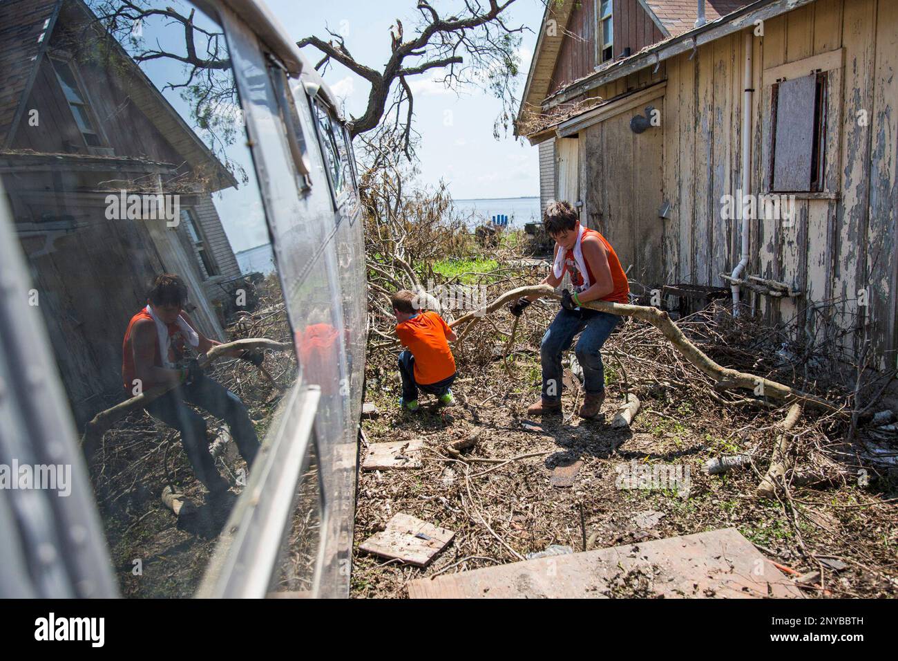 Corey Carpenter, 7, left, and Layton Carpenter, 12, right, help pick up ...