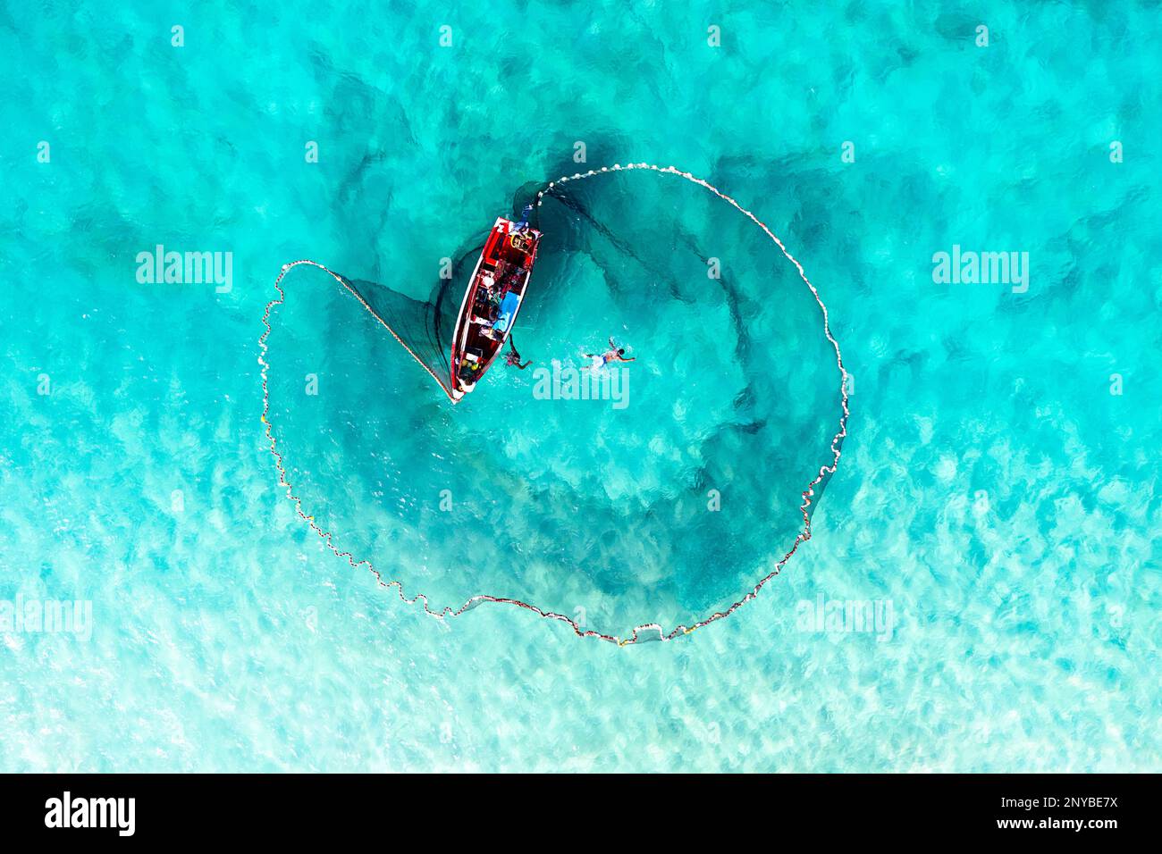 Aerial view of local fishermen fishing with fishing net from a boat in ...