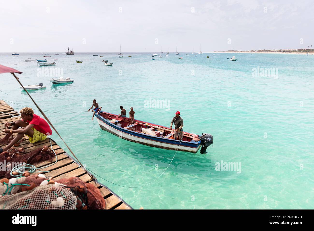 Famous wooden pier in Santa Maria town on Sal island, full of fishermen ...