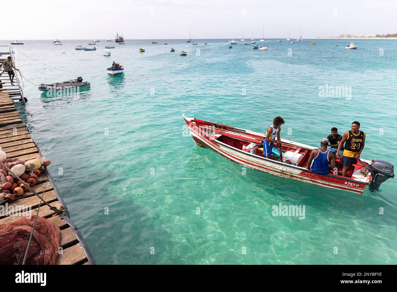 Famous wooden pier in Santa Maria town on Sal island, full of fishermen ...
