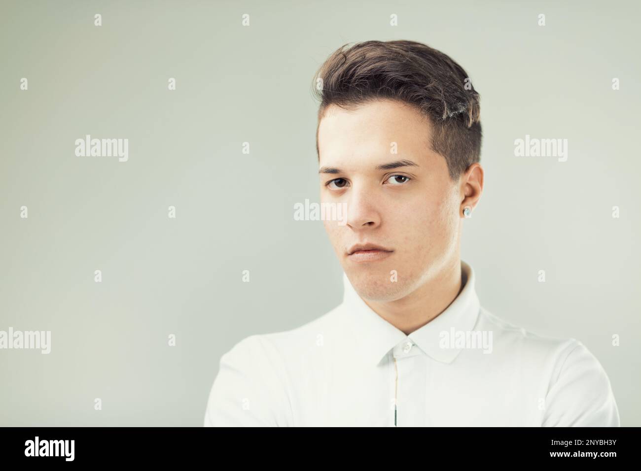 Horizontal portrait of young man with short hair and serious expression ...