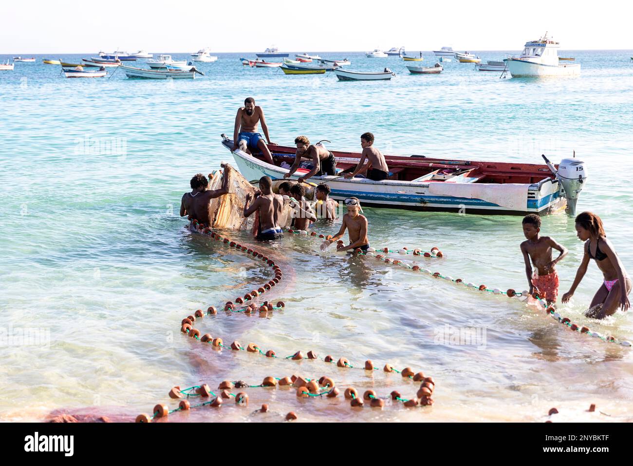 Local fishermen fishing with a net in a shallow wate on a local sandy ...