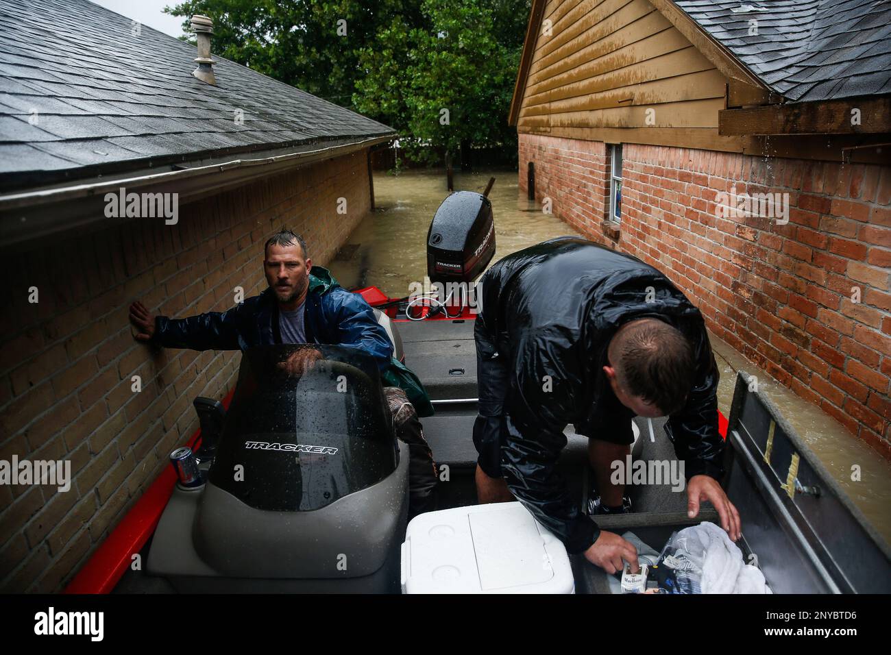 Kevin Johnston, left, navigates his boat between two flooded houses in ...