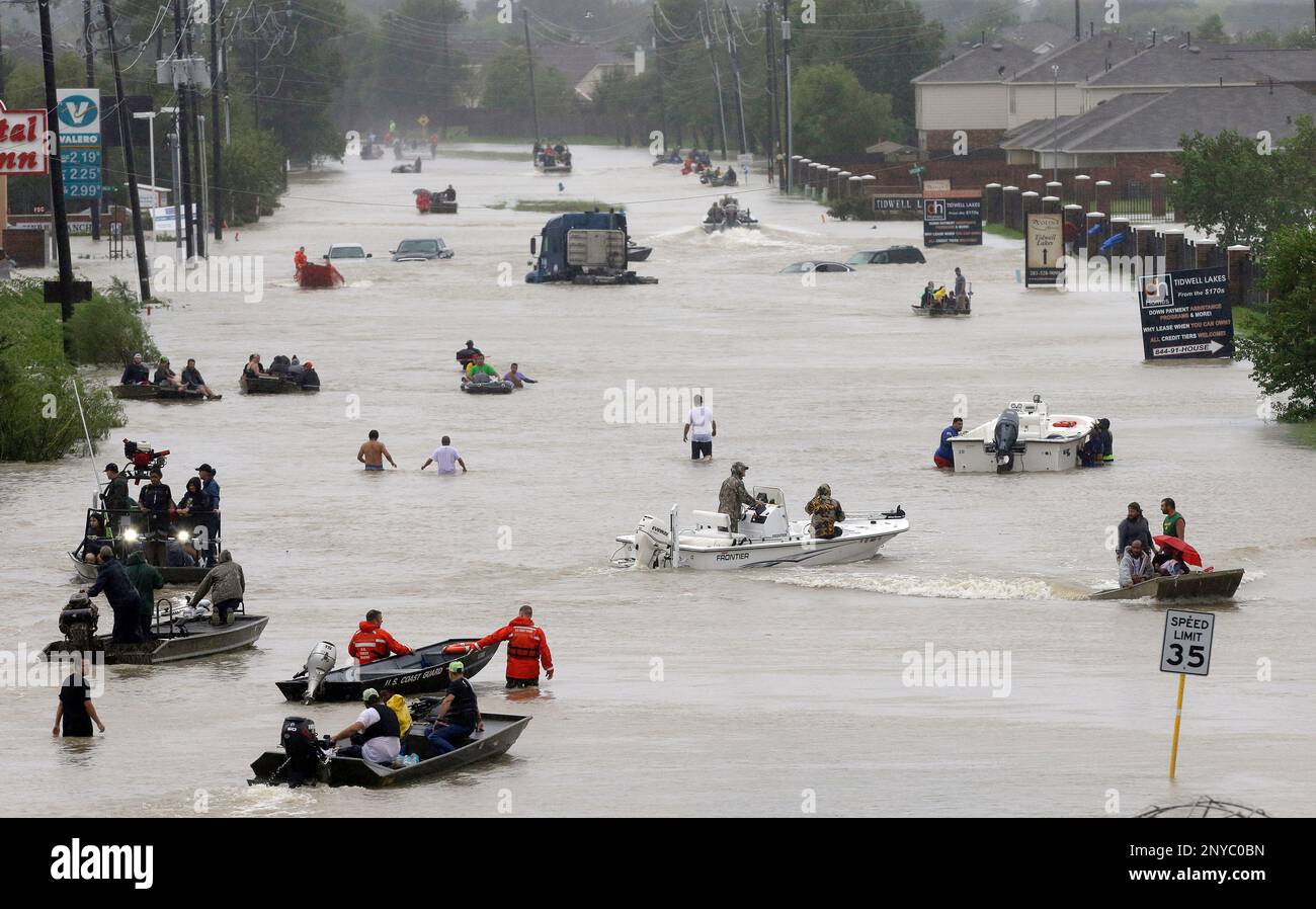 People and rescue boats line a street at the east Sam Houston Tollway ...