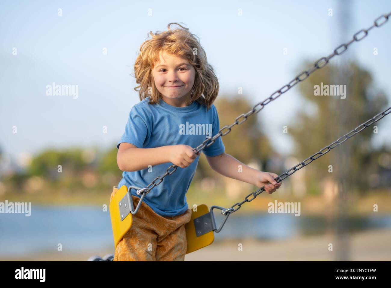 Funny kid on swing. Little boy swinging on playground. Happy cute excited child on swing. Cute ...