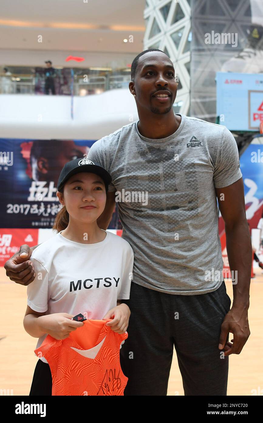 NBA star Dwight Howard, right, poses for photos with a fan at a ...