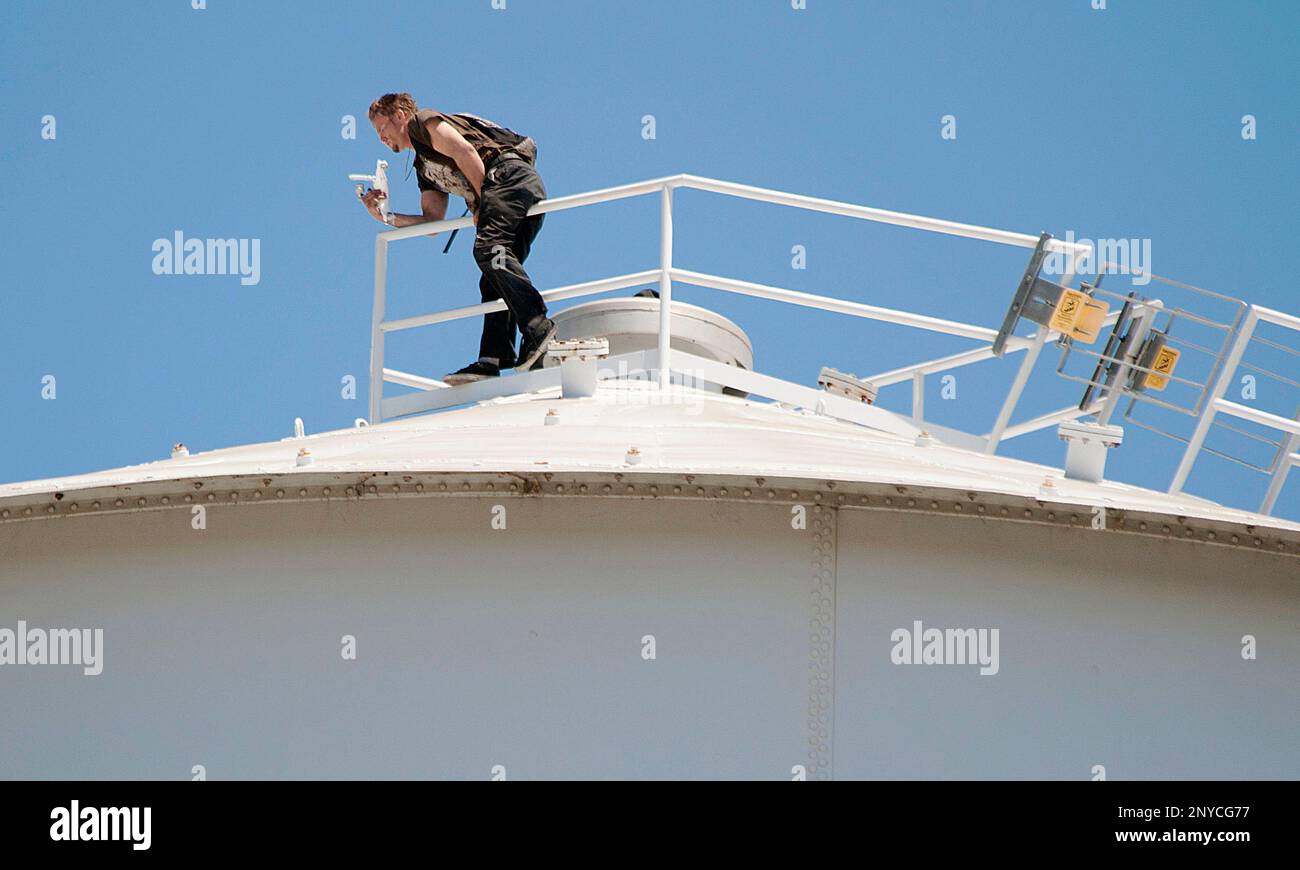 A man starts to climb over the safety railing as police negotiate him ...