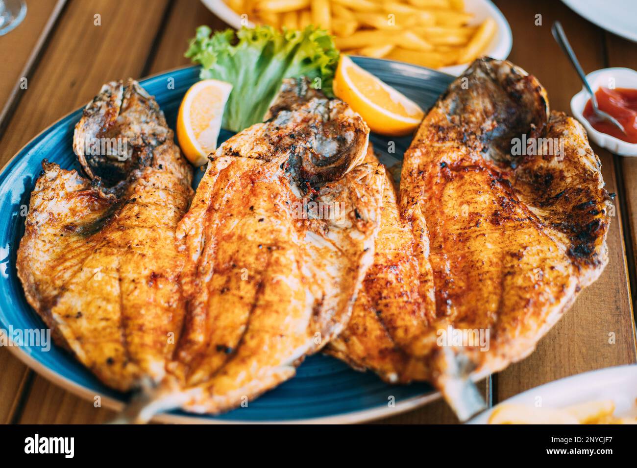 Dish with Gilt-head bream Fish With orange and french fries. Dorada ...
