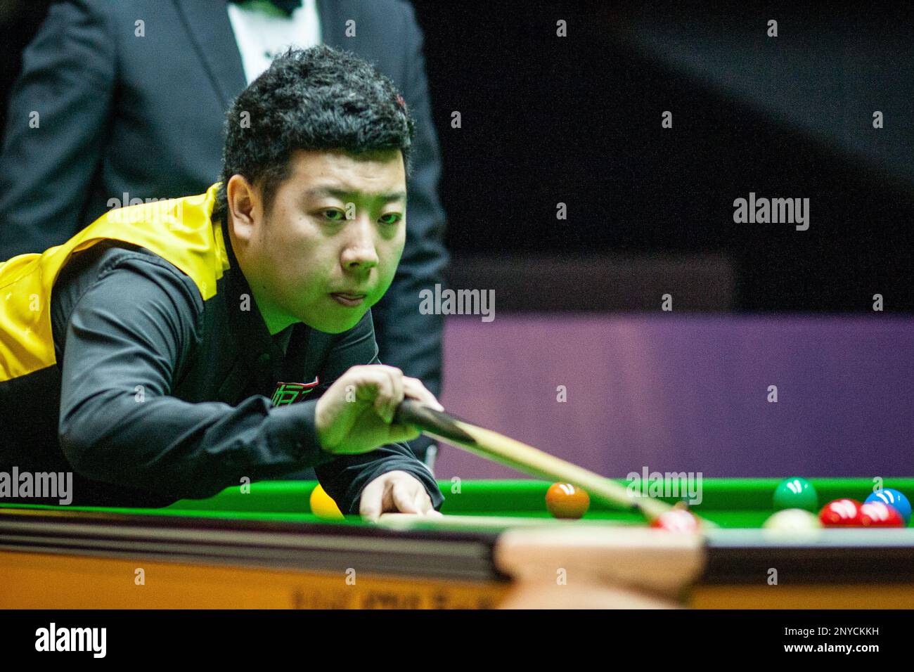Li Hang of China plays a shot to Luca Brecel of Belgium in the ...