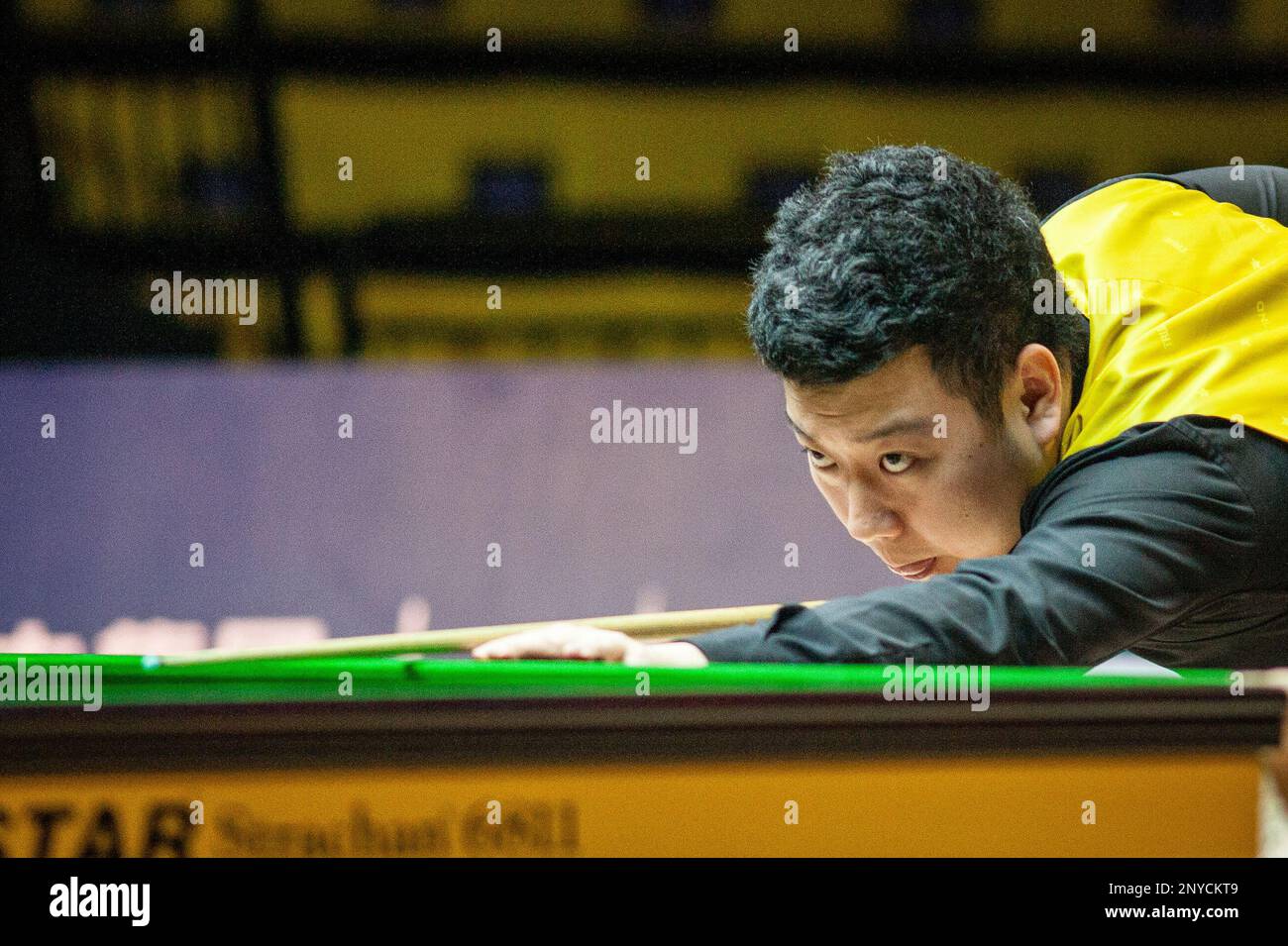 Li Hang of China plays a shot to Luca Brecel of Belgium in the ...