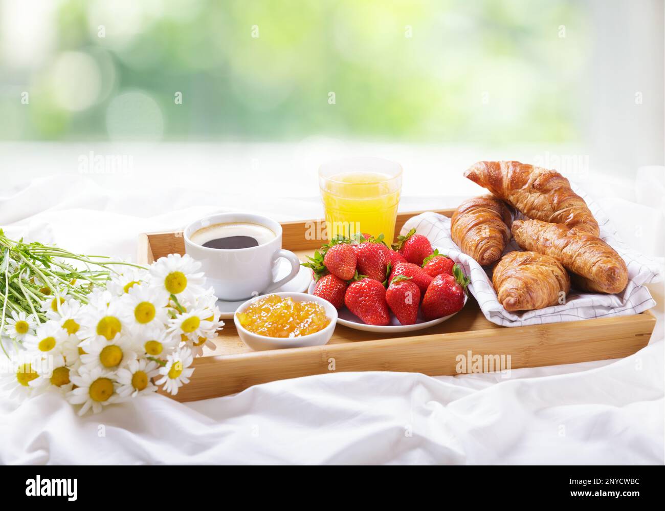 Breakfast in bed. Tray with cup of coffee, jam, orange juice, fresh ...