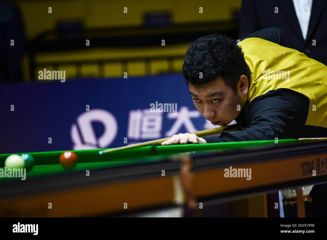 Li Hang of China plays a shot to Matthew Stevens of Wales in their ...