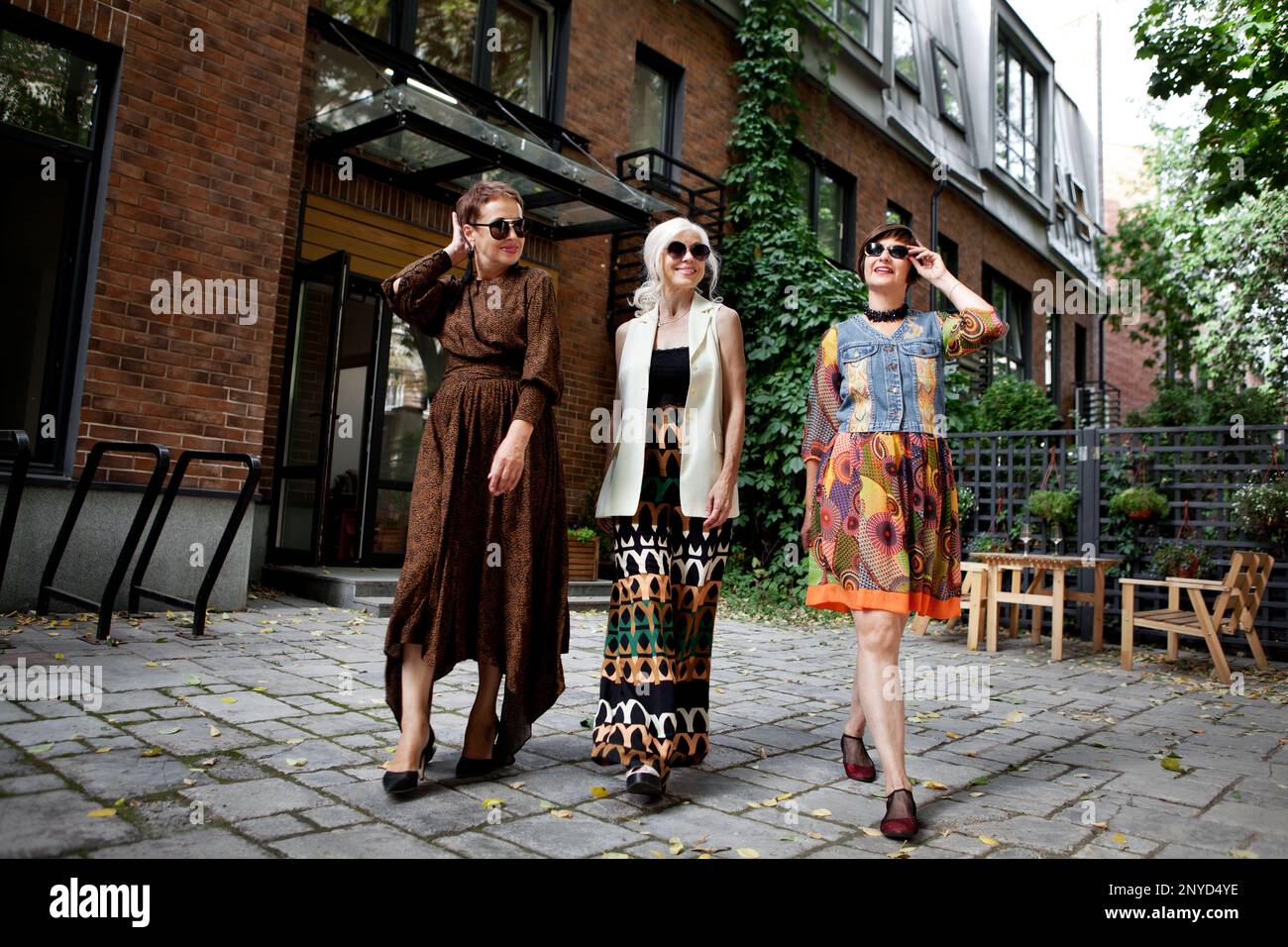 Group of full length elderly women having fun walking city street ...