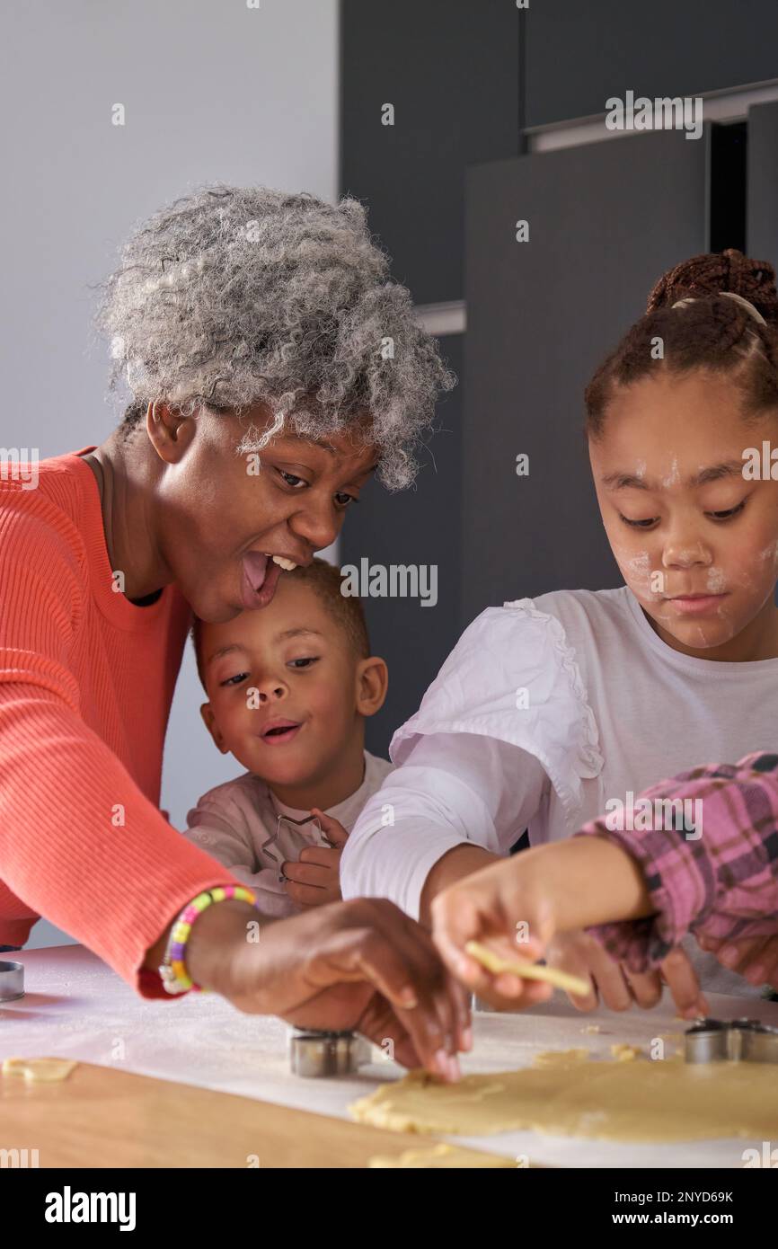 African family cutting cookie shapes in a cookie dough in the kitchen ...