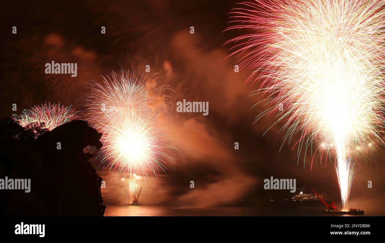 A Lion Rock(L), know as shishiiwa, is silhouetted agaisnt fireworks in ...