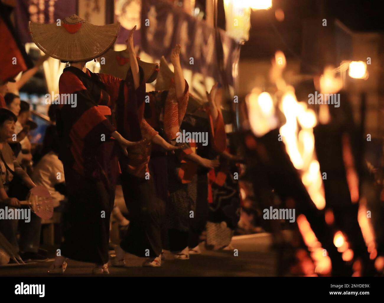 Female dancers wearing amigasa, straw hats, and black hoods perform in ...