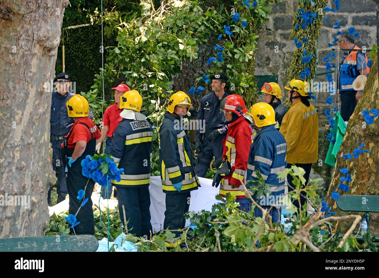 Firefighters hold a blanket as bodies are removed from the scene where ...