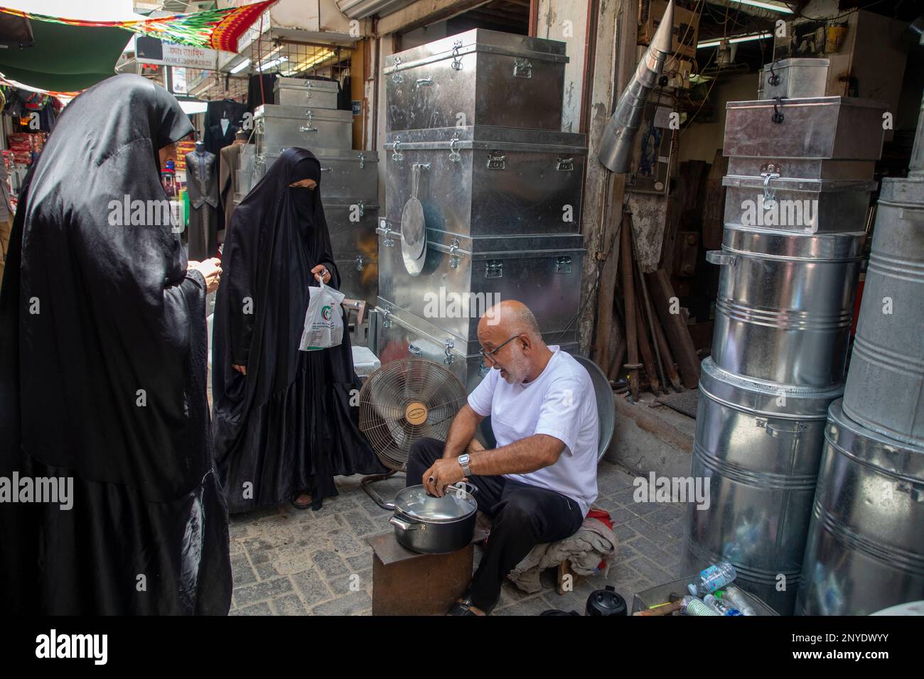 A Bahraini old man repairs crockery outside his shop at the Bab al ...