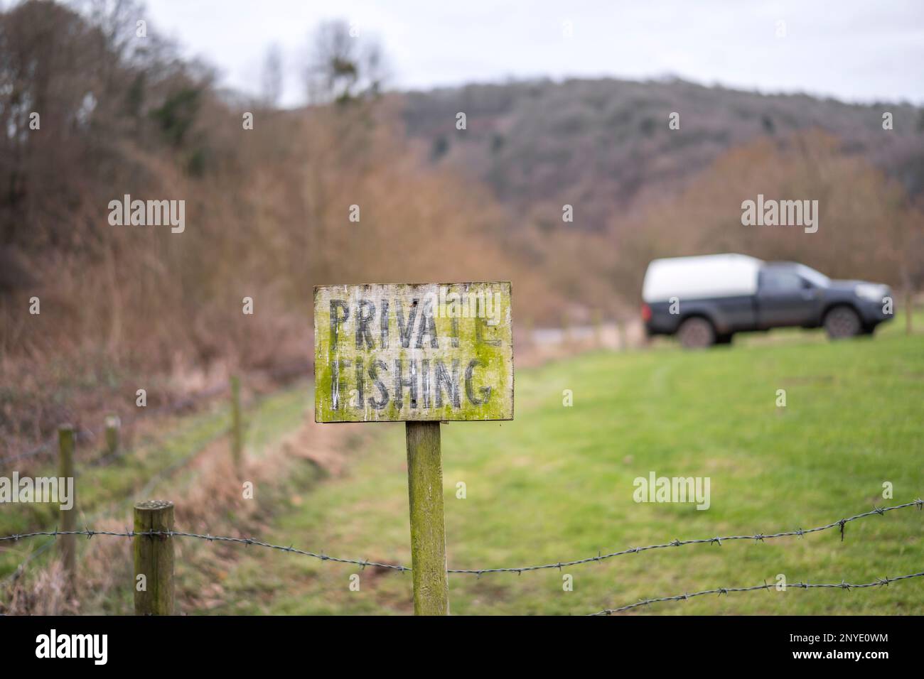 Old, tatty 'Private Fishing' sign by a river footpath in the UK ...