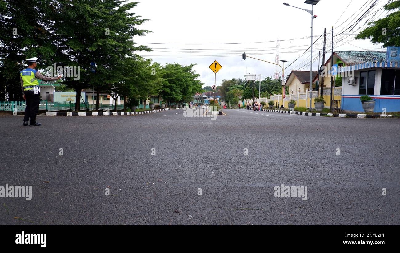 A Policeman Standing On An Empty Street In Muntok Town Early In The ...