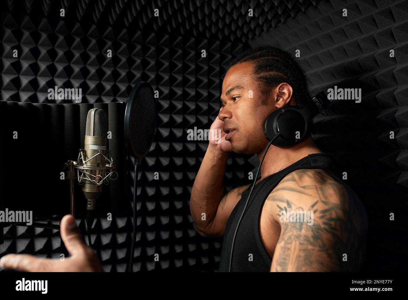 Young African American singer in a recording studio, recording a ...