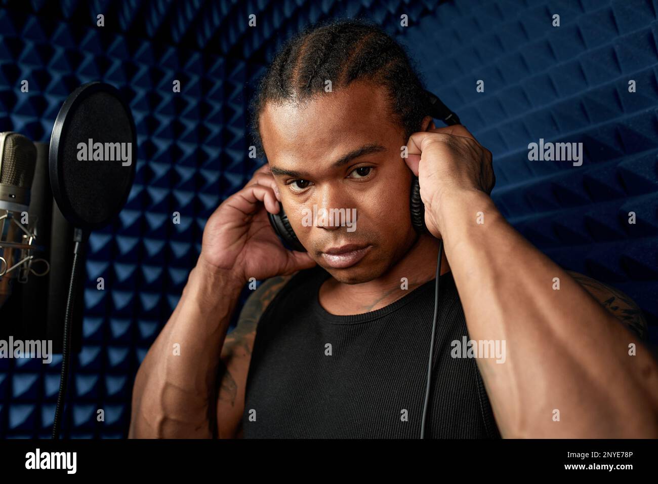 Young African American singer in a recording studio, recording a ...