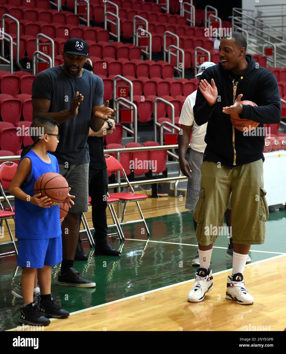 NBA star Metta World Peace, left, and Paul Pierce instruct a younger ...