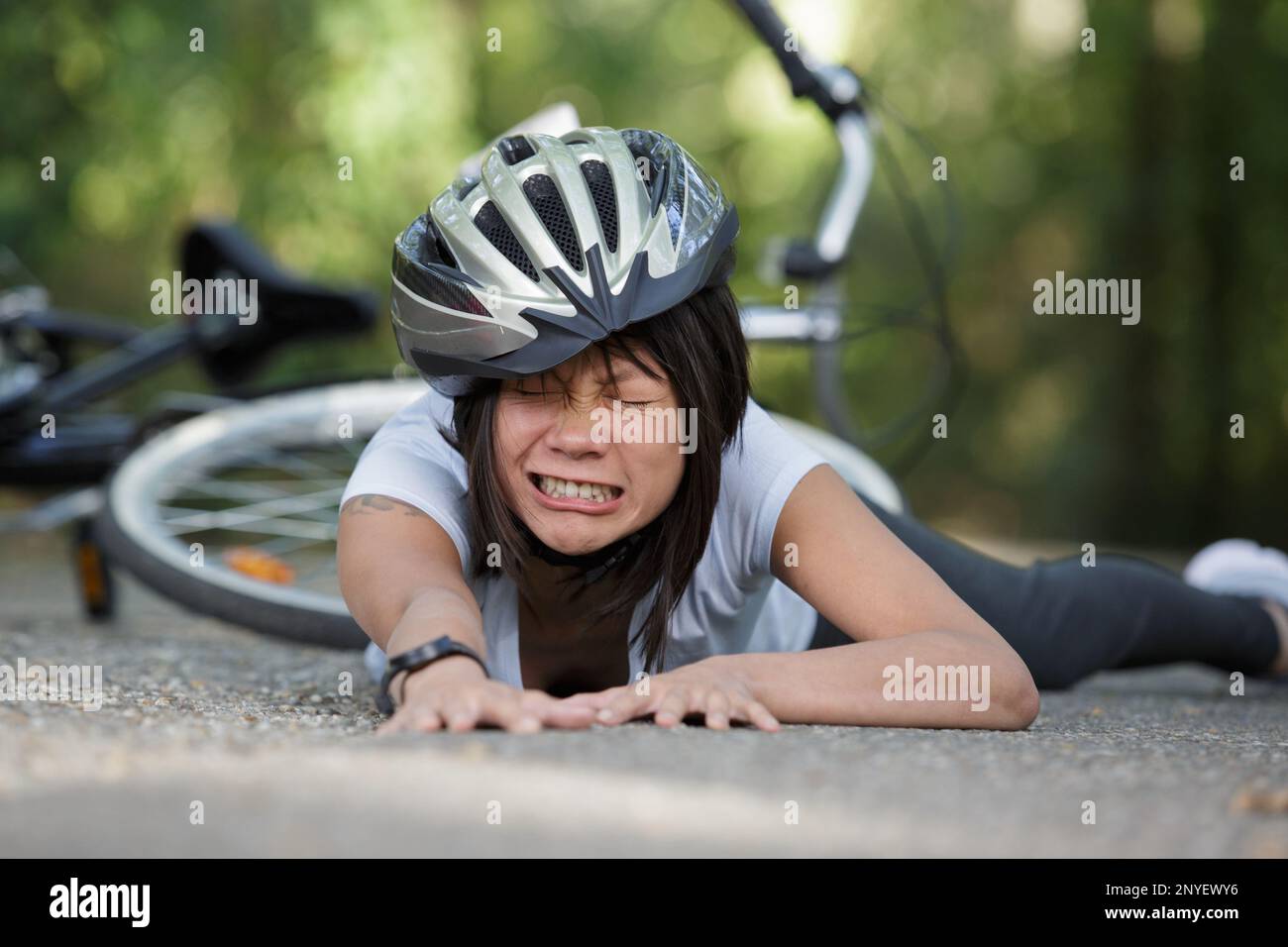 young woman with pain when falling down off her bicycle Stock Photo - Alamy