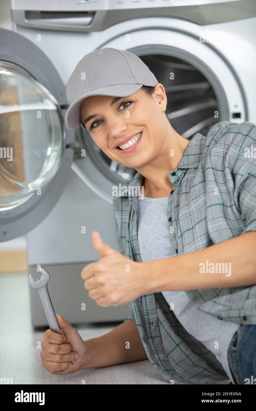 female worker repairing washing machine Stock Photo - Alamy