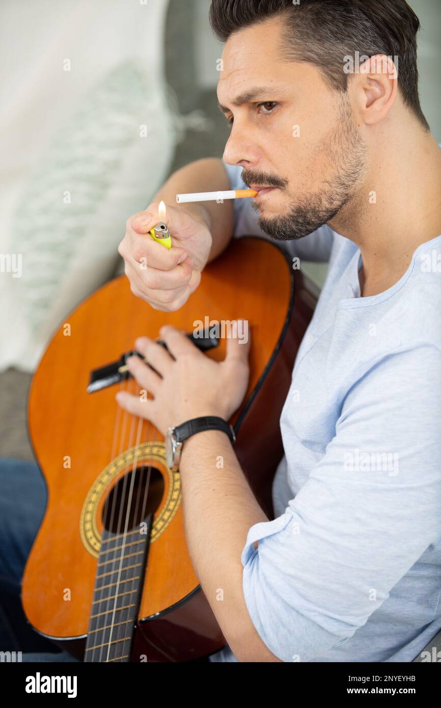 man smoking while playing guitar Stock Photo - Alamy