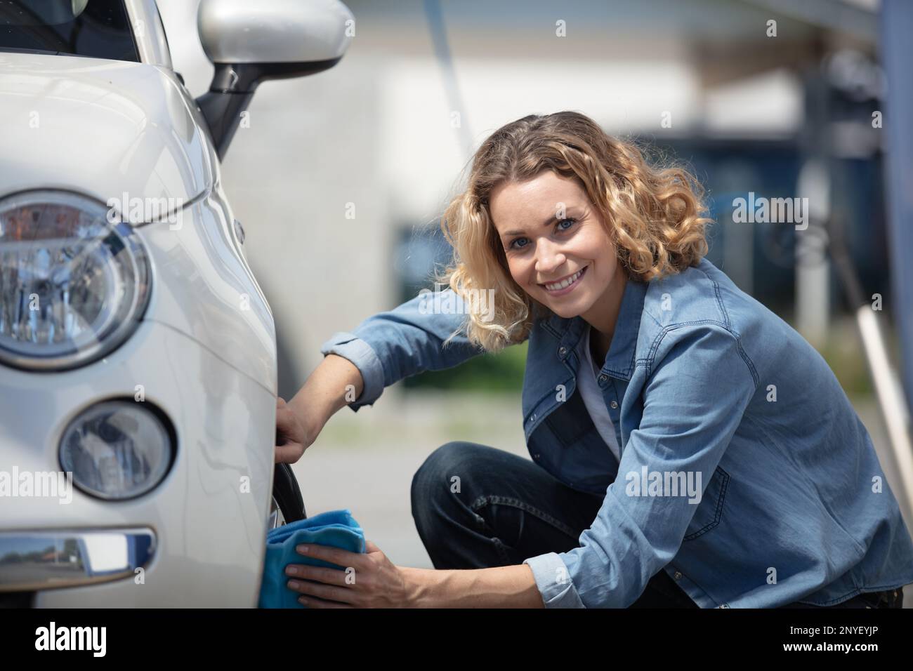 pretty woman cleaning the wheels of her car Stock Photo - Alamy