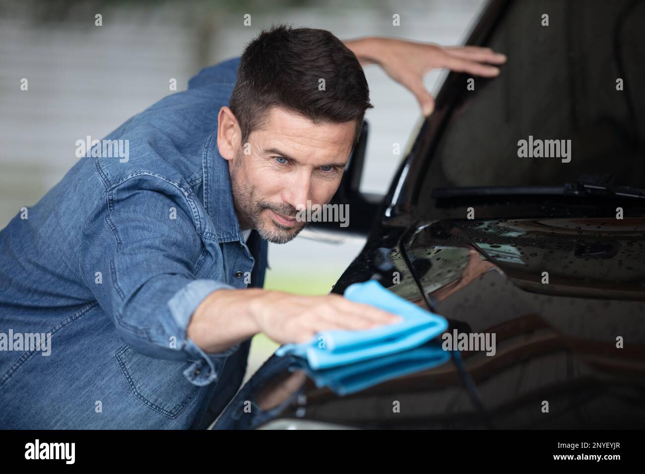 Professional worker washing black car hi-res stock photography and ...