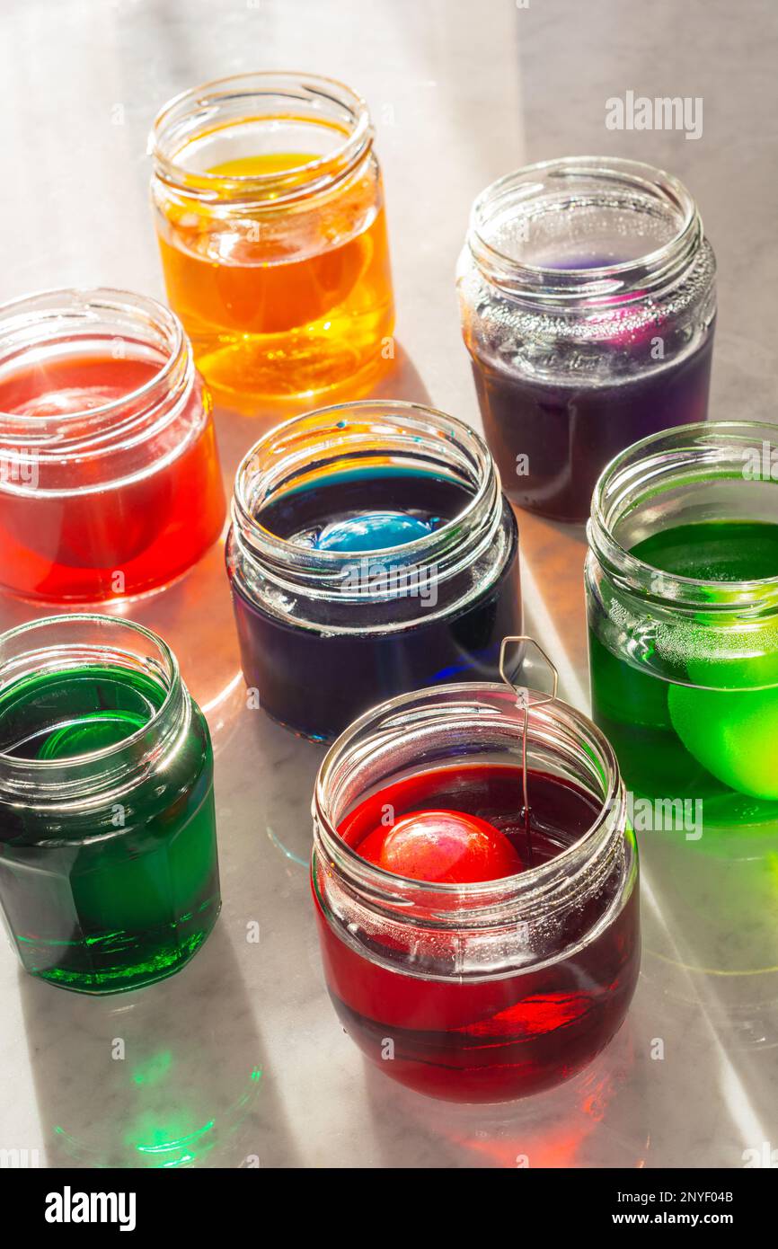 Dyeing Easter Eggs in Colorful Dye in Glass Jars on Marble Counter ...