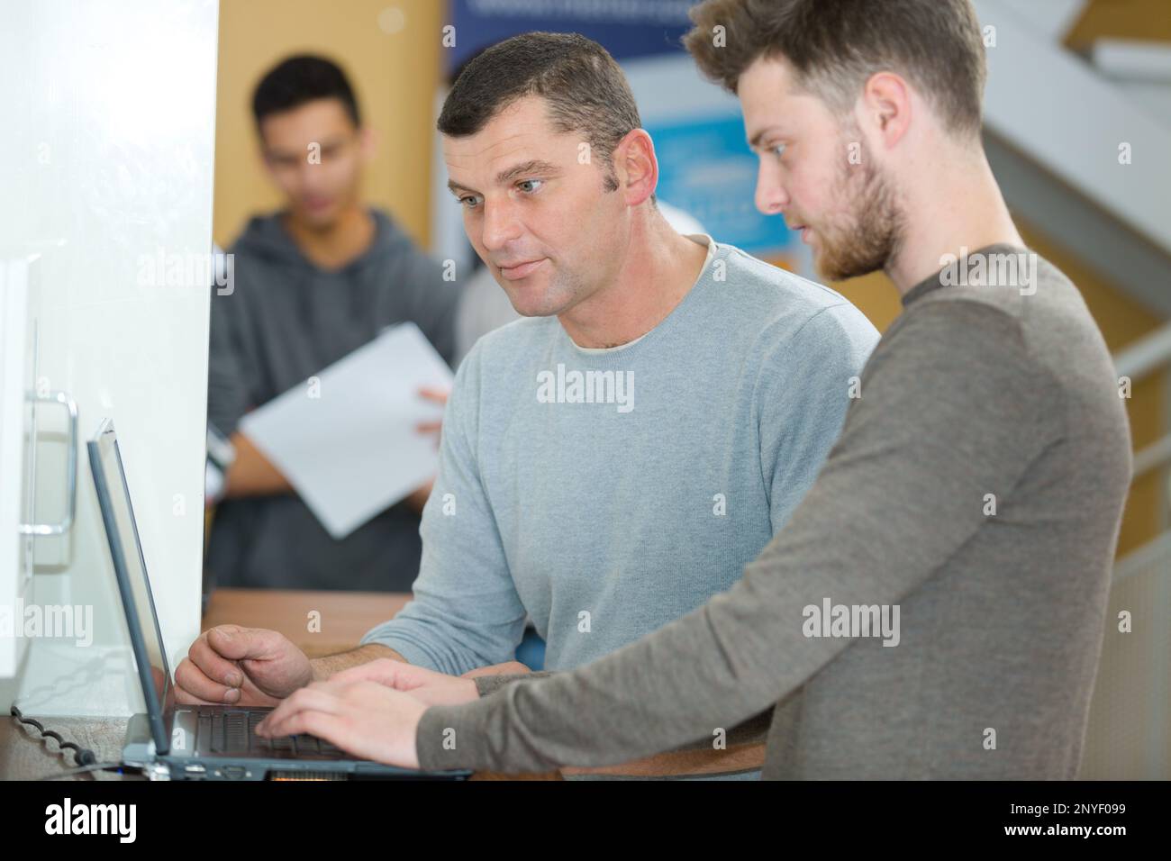 man teacher and a student with a computer Stock Photo - Alamy