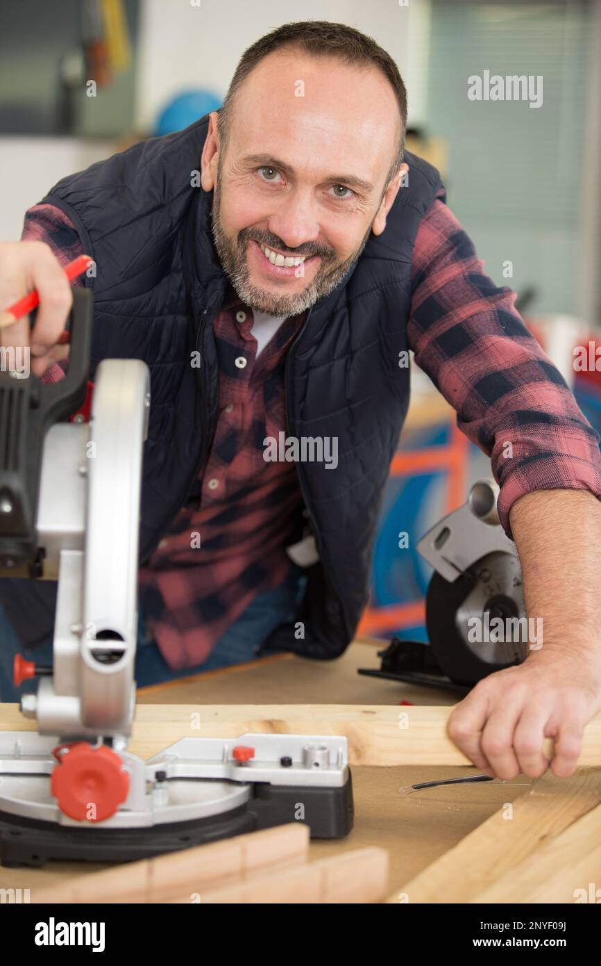 carpenter cutting wood in workshop Stock Photo - Alamy