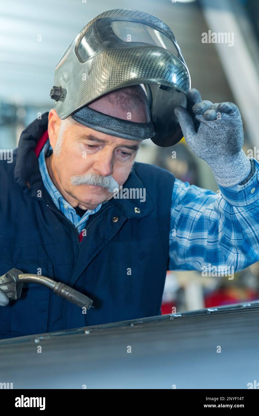 senior man wearing visor to use blow torch Stock Photo - Alamy