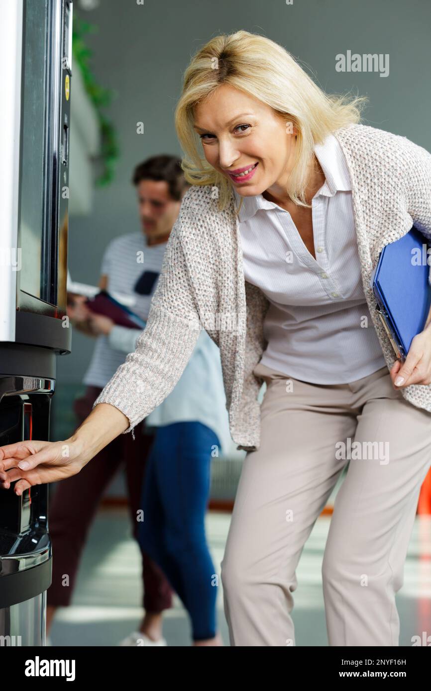 pretty woman using coffee vending machine Stock Photo - Alamy