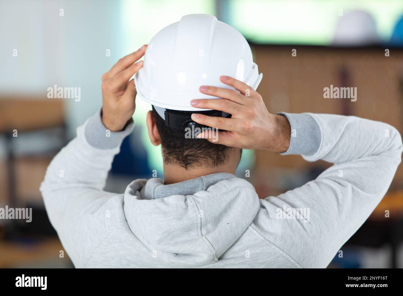 workman adjusting his hard hat to fit correctly Stock Photo - Alamy