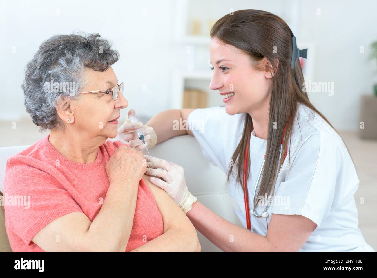 nurse giving injection to senior woman in the arm Stock Photo - Alamy