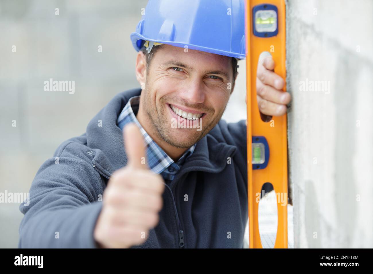 professional worker with spirit level and thumb up Stock Photo - Alamy