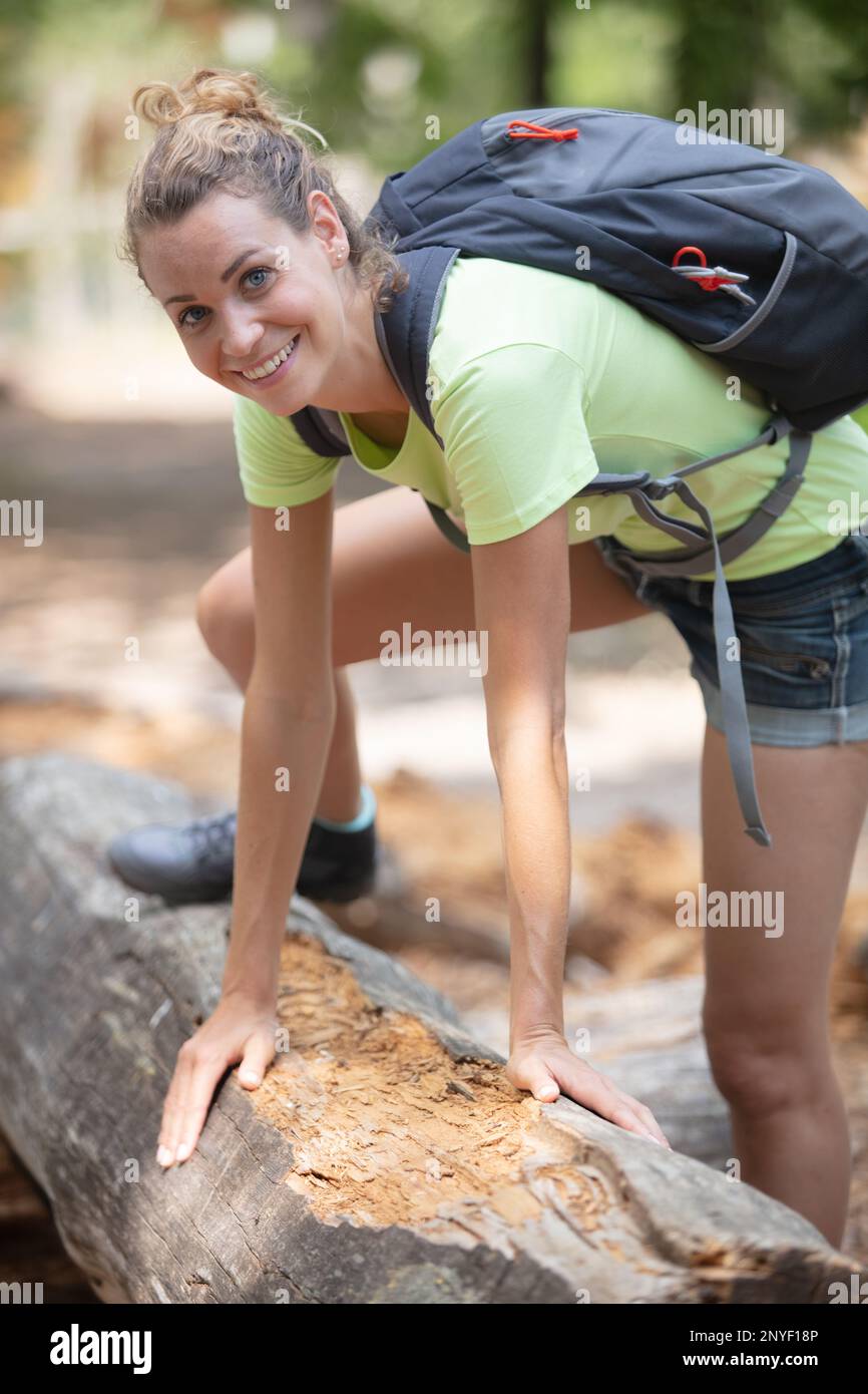 woman climbing over fallen tree trunk in woods Stock Photo - Alamy