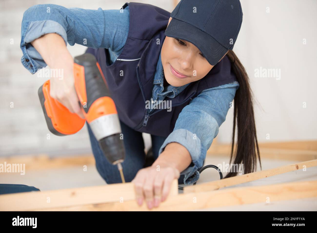 female carpenter at work using hand drilling machine Stock Photo - Alamy
