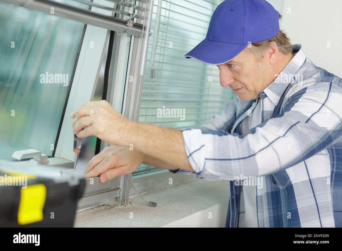 senior handyman fixing window renovation Stock Photo - Alamy